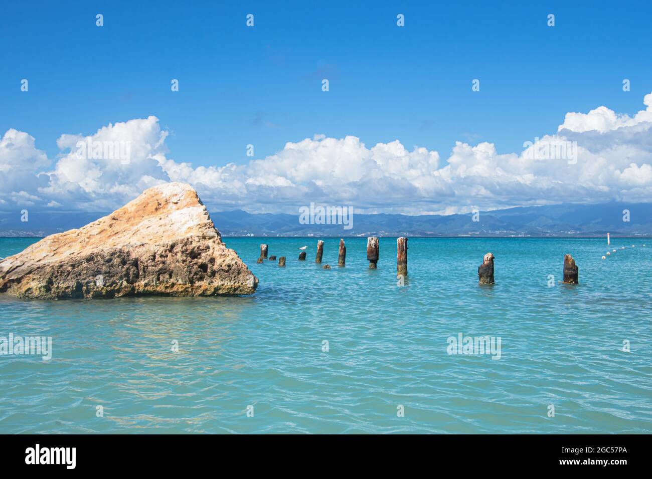 A large triangular rock and the remnants of an old dock in the ...