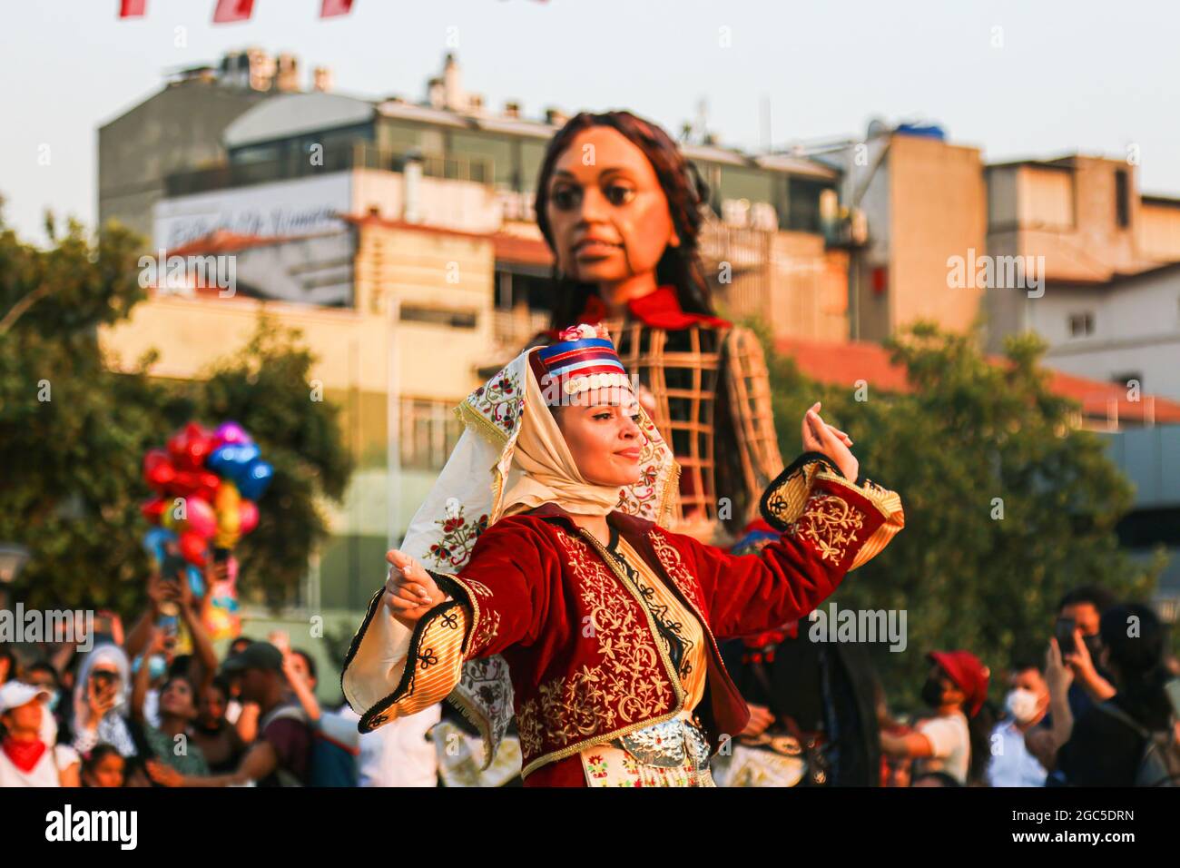 People wearing traditional outfits perform for the giant puppet "Amal ...