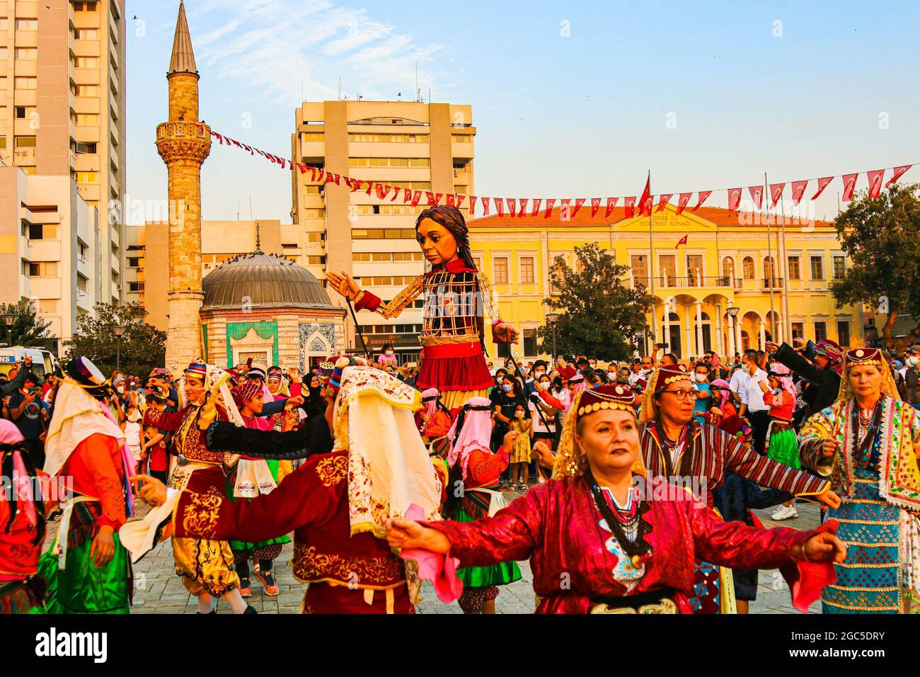 People wearing traditional outfits perform for the giant puppet "Amal ...