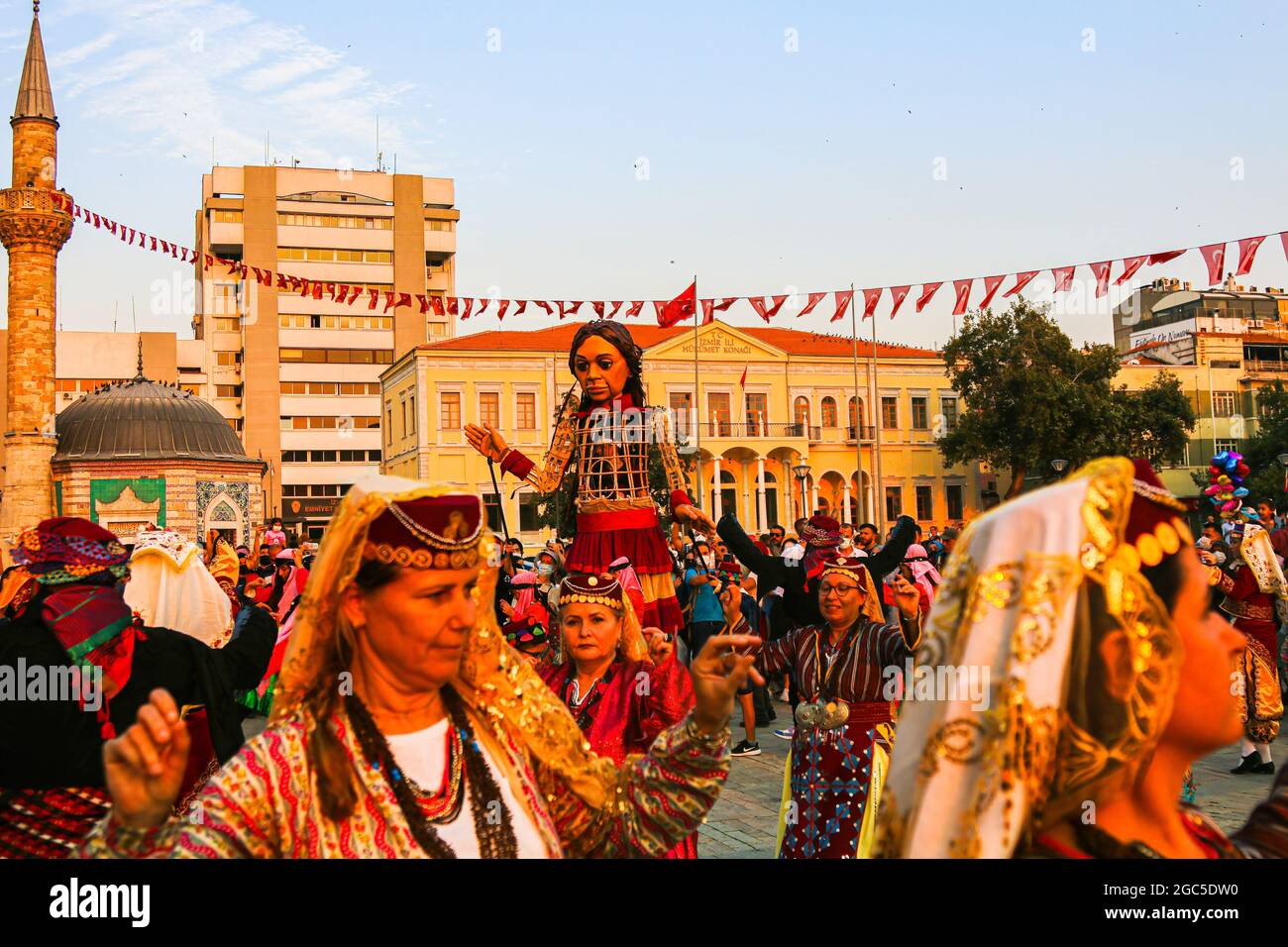 People wearing traditional outfits perform for the giant puppet "Amal ...