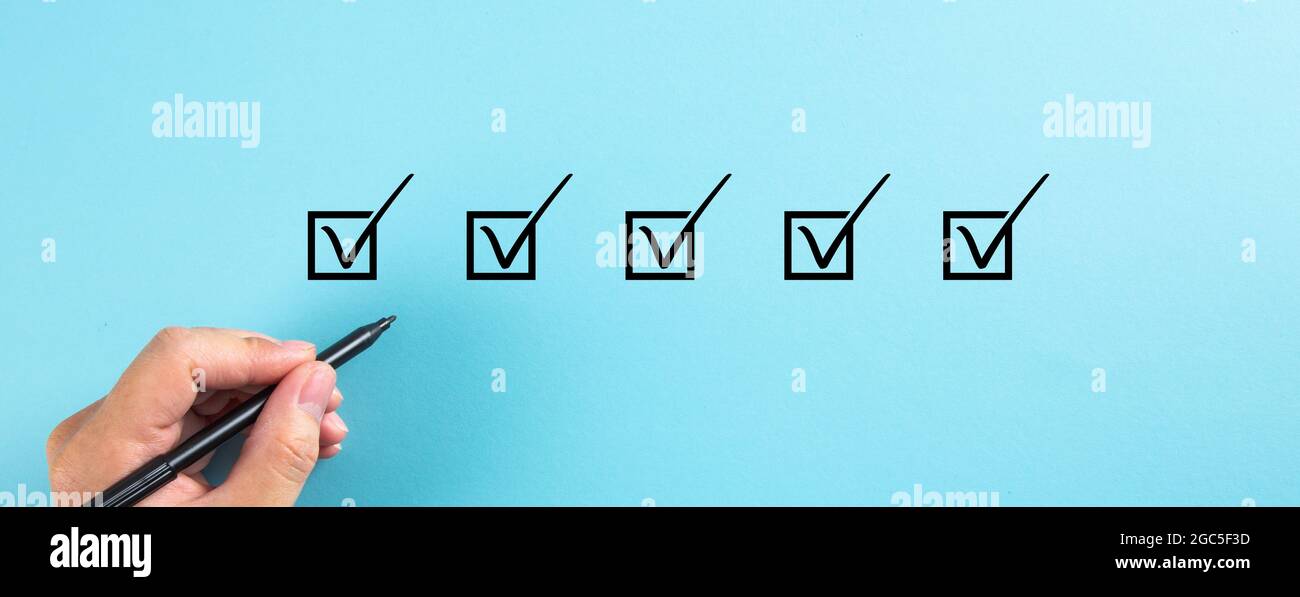 Close-up, Hand holding black pen checking mark on check boxes. Survey ...