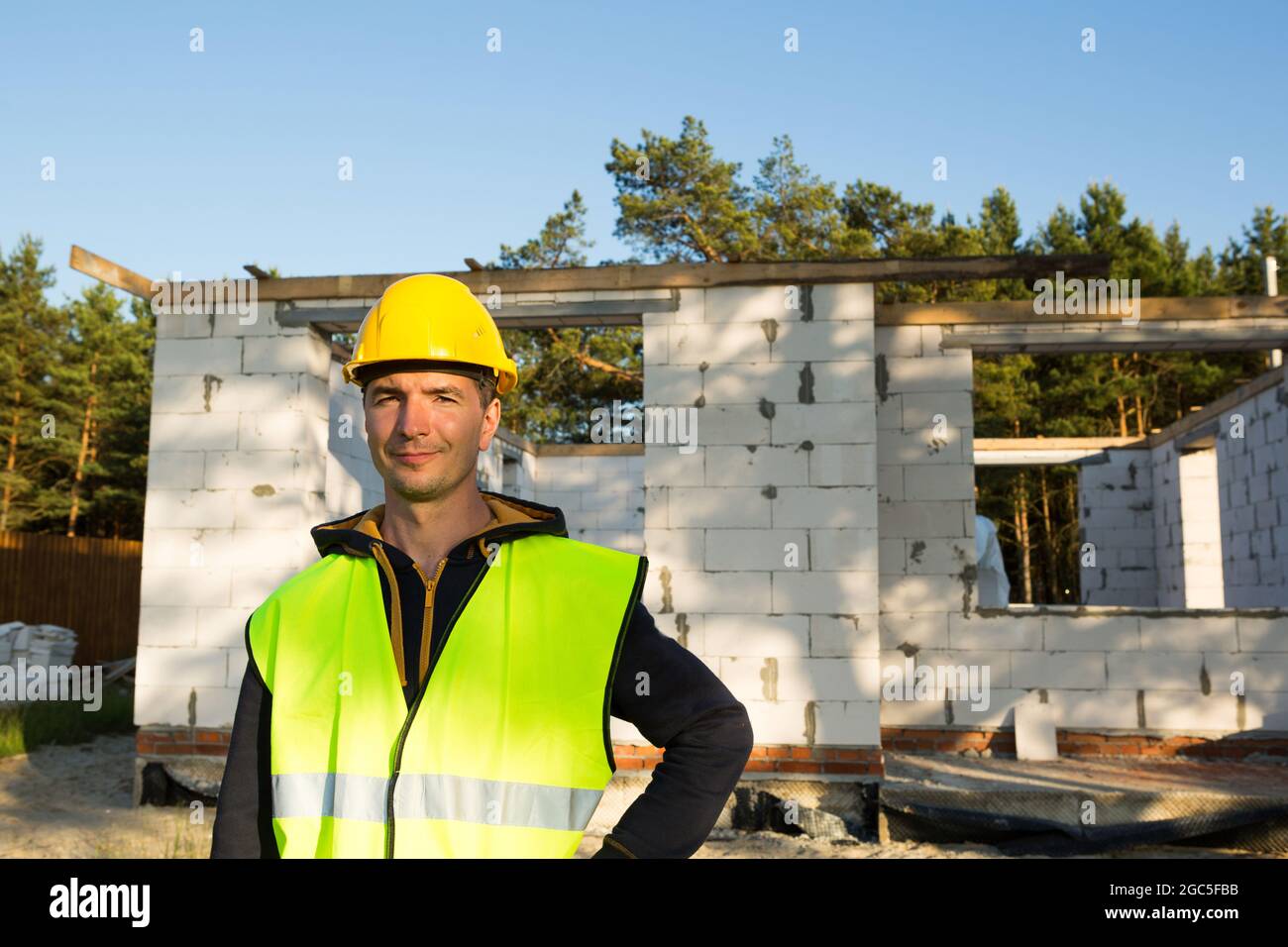 Project architect stands near construction site of a house with the ...