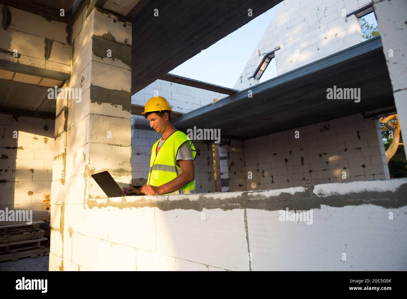 Construction engineer on the construction site of a house made of ...