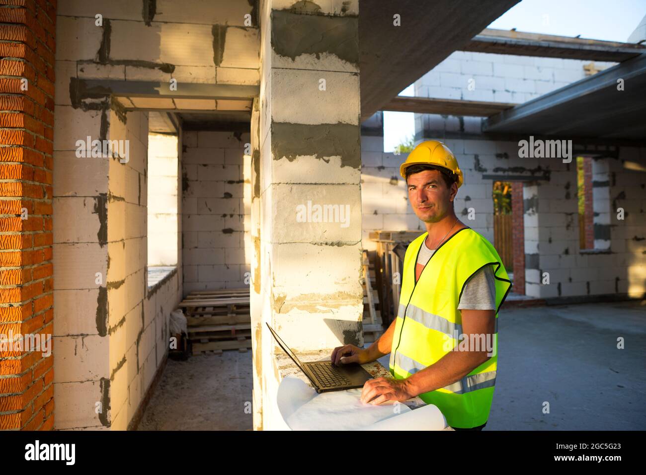 Construction engineer on the construction site of a house made of ...