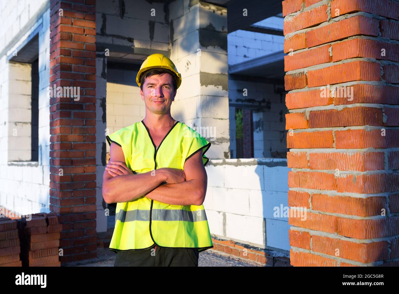 Project architect stands near construction site of a house with the ...