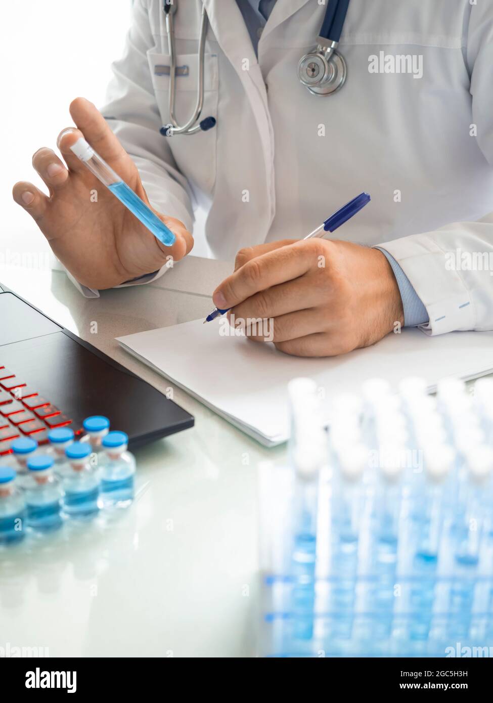 Vertical photo of a doctor's hand holding a test tube with a modern ...