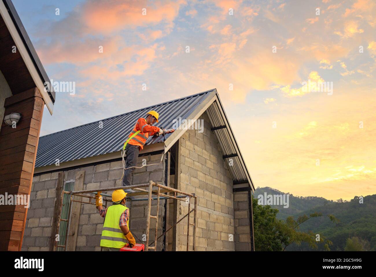 Roofer working on roof structure of building on construction site ...