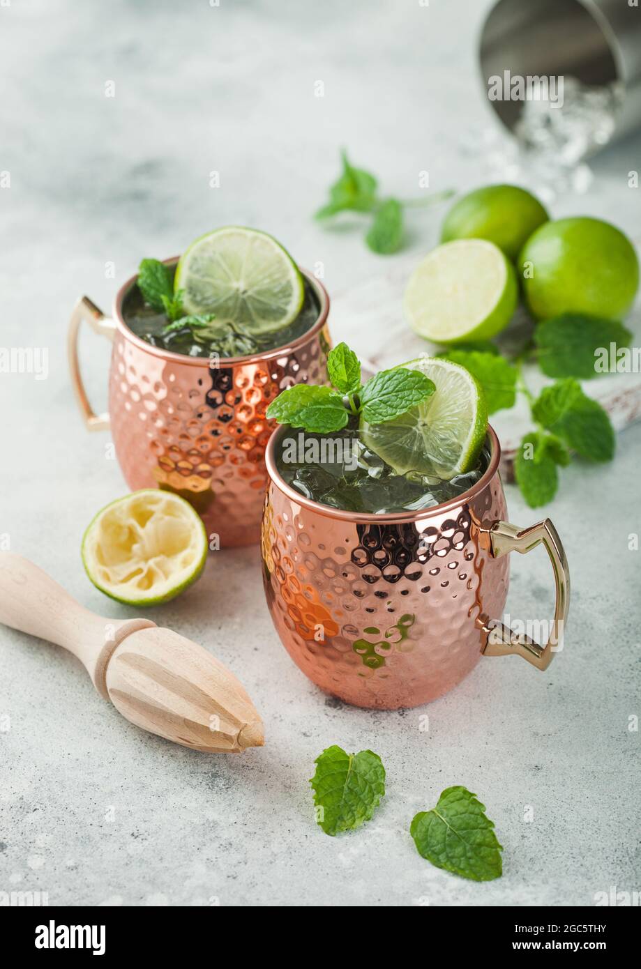 Moscow mule cocktail in a copper mug with lime and mint and wooden ...