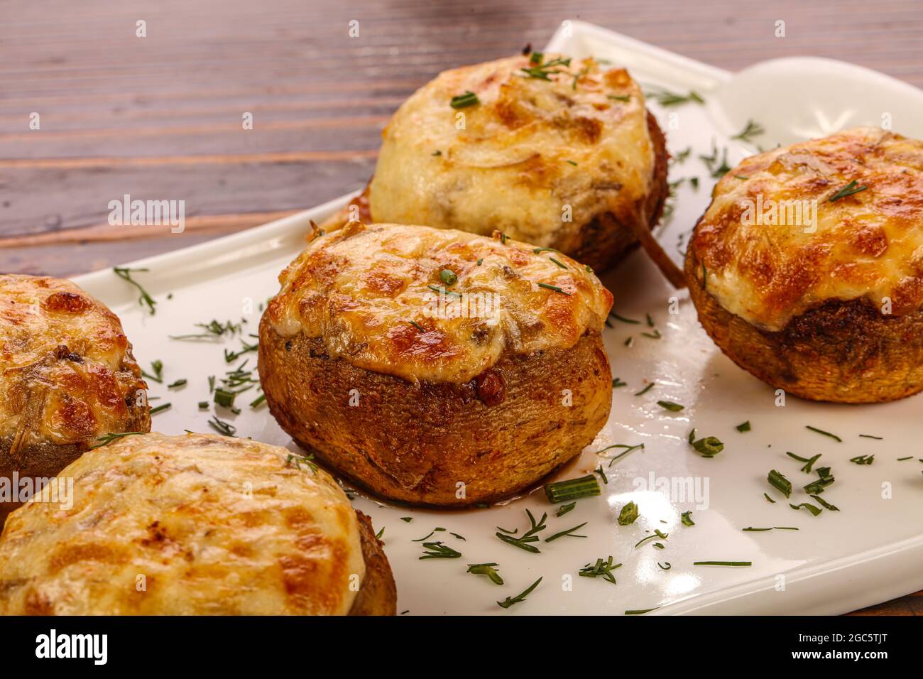 Baked champignon with cheese and green herbs Stock Photo - Alamy