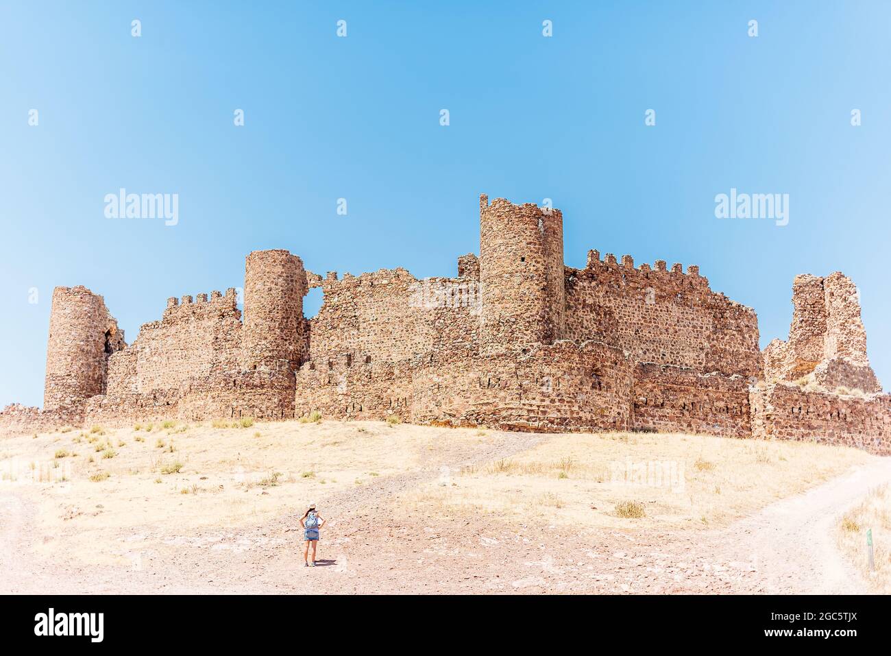 Ancient walled castle with a woman standing in front of it Stock Photo ...