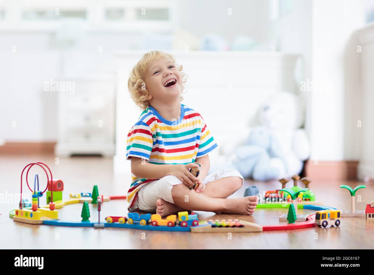 Kids play with wooden railway. Child with toy train. Educational toys ...