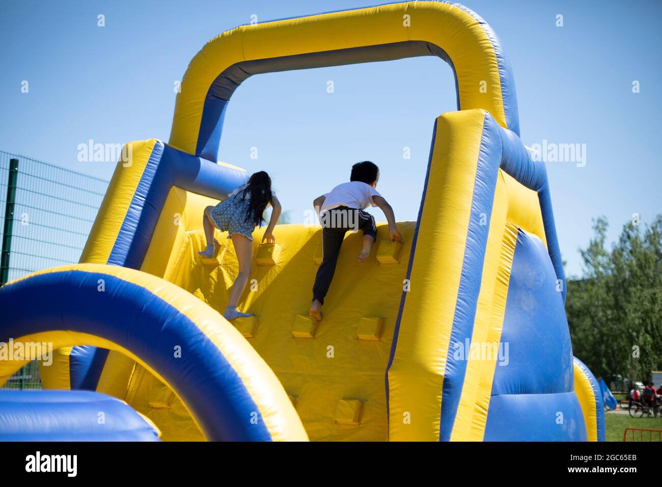 Children climb an inflatable slide. Inflatable obstacle course for fun ...
