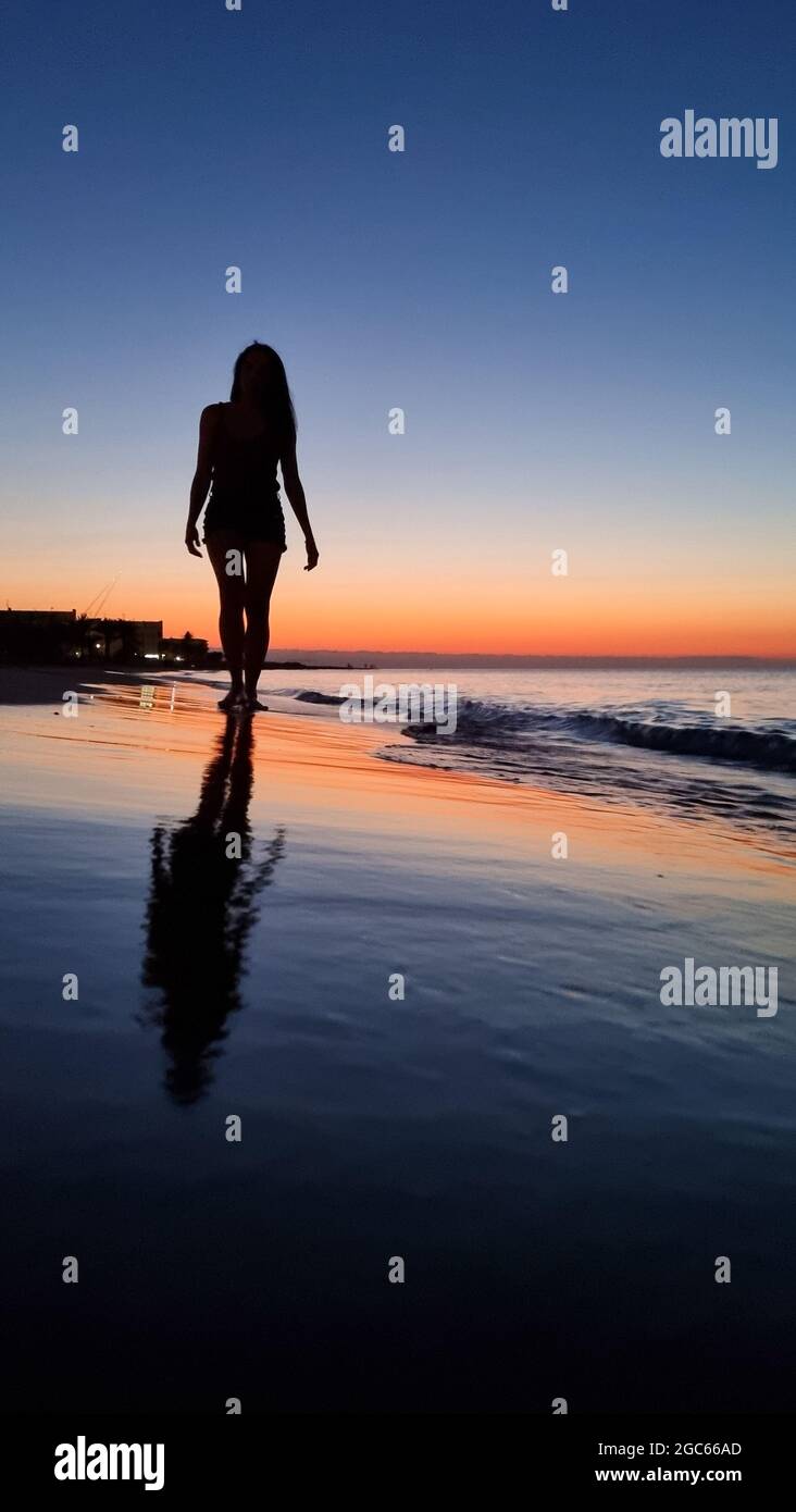 Vertical shot of a silhouette of a Hispanic female on the beach at ...