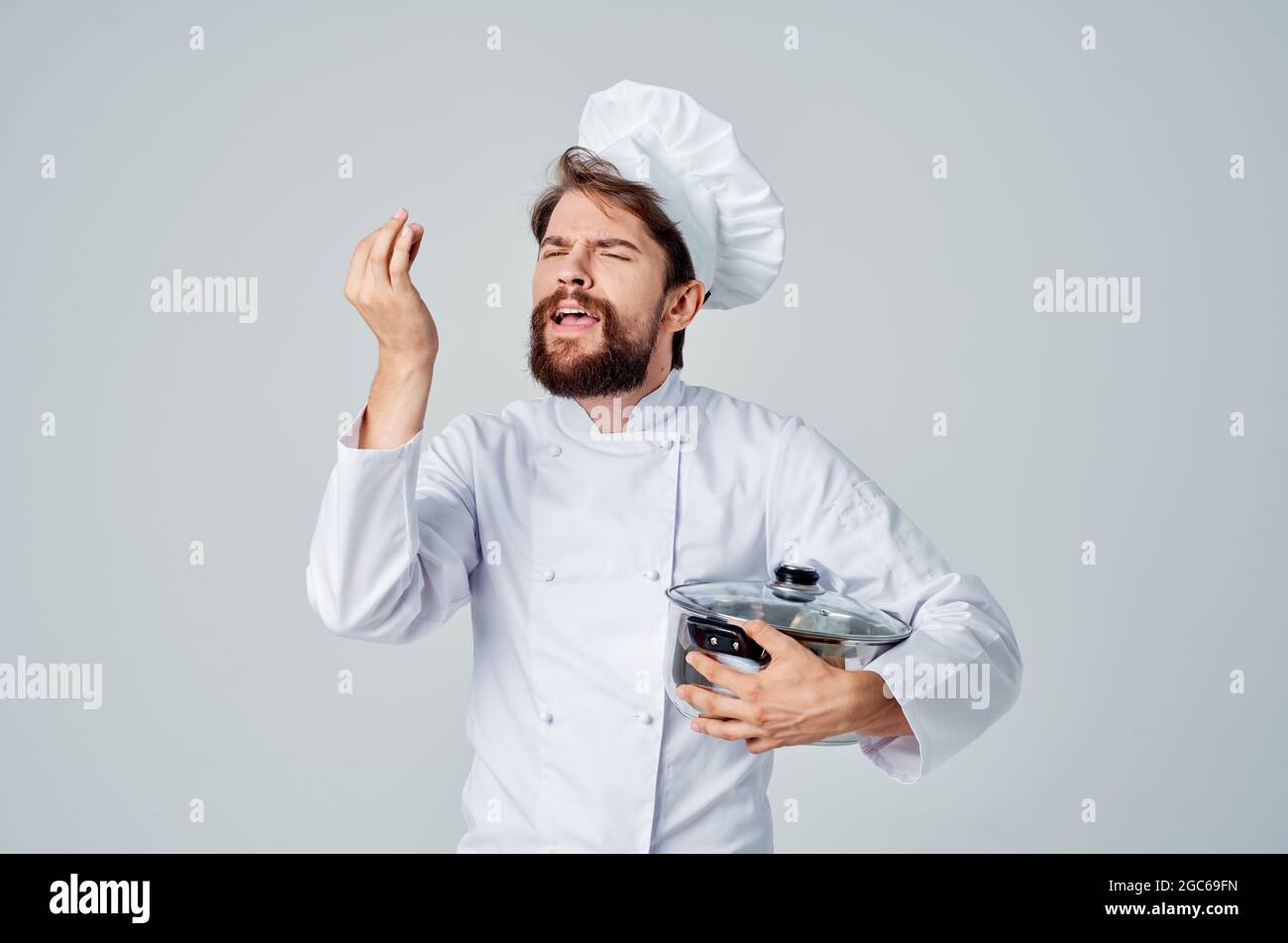 Cheerful male chef with a saucepan in his hands cooking food kitchen ...