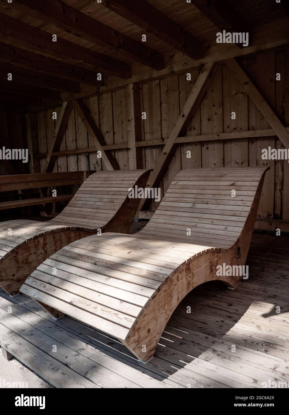 Vertical shot of wooden curvy chairs for relaxation and suntan in spa ...