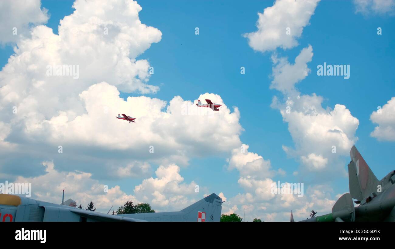 Two small airplanes flying thorough the sky. A mixture of clouds and ...
