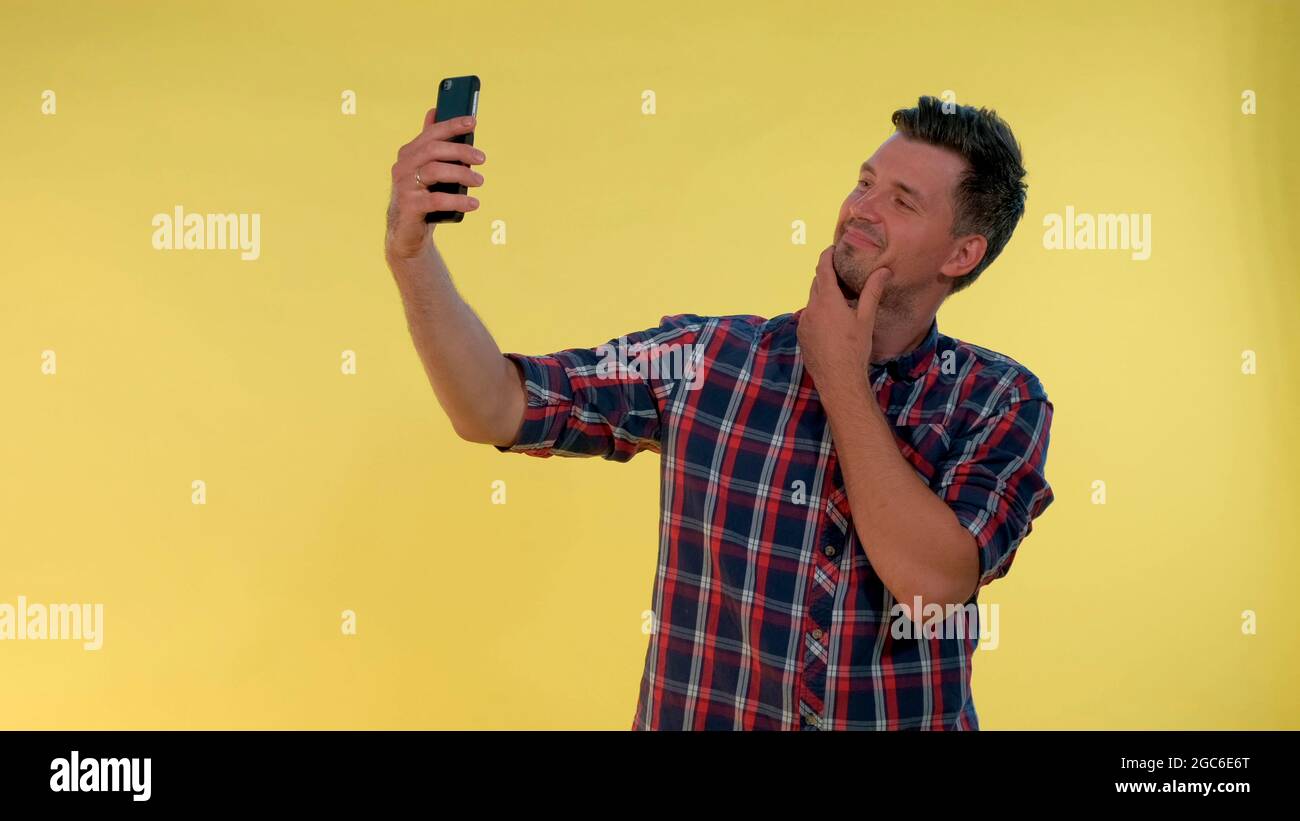 Attractive tall boy making selfie on smartphone. He smiling and ...