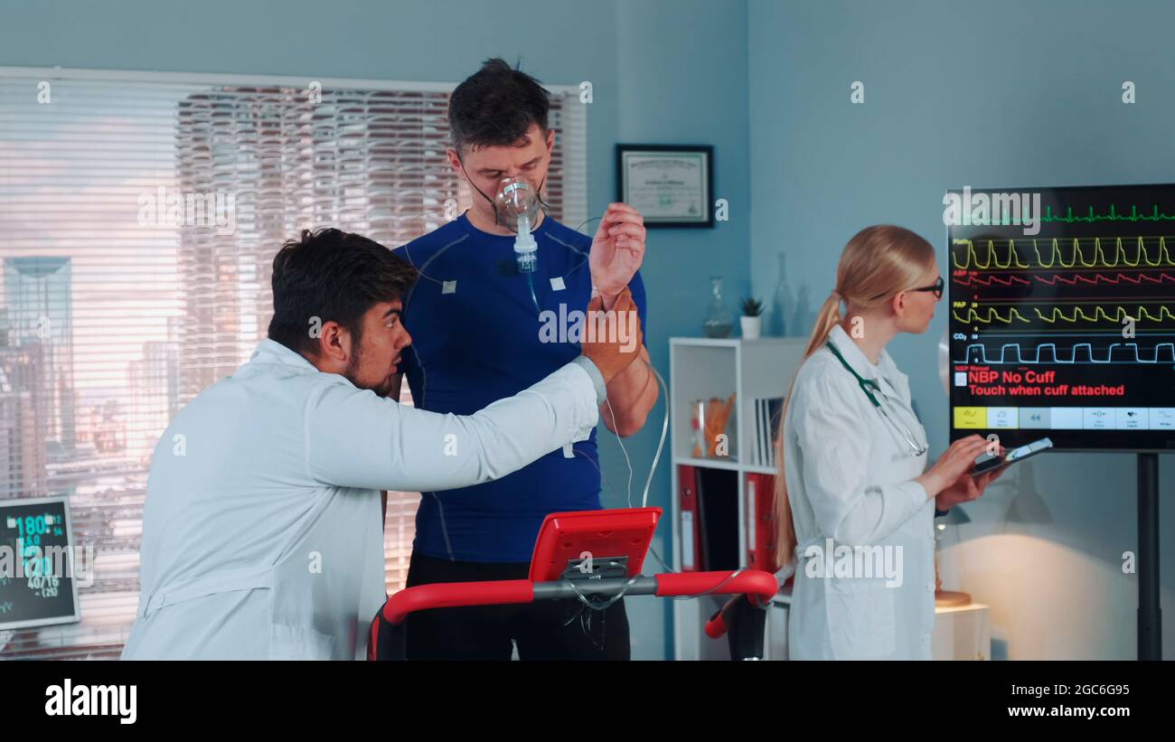 Doctor preparing sportsman in oxygen mask for cardio respiratory test ...