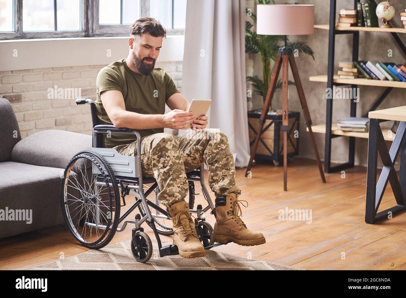 Disabled handsome military man sitting in a wheelchair and using a ...