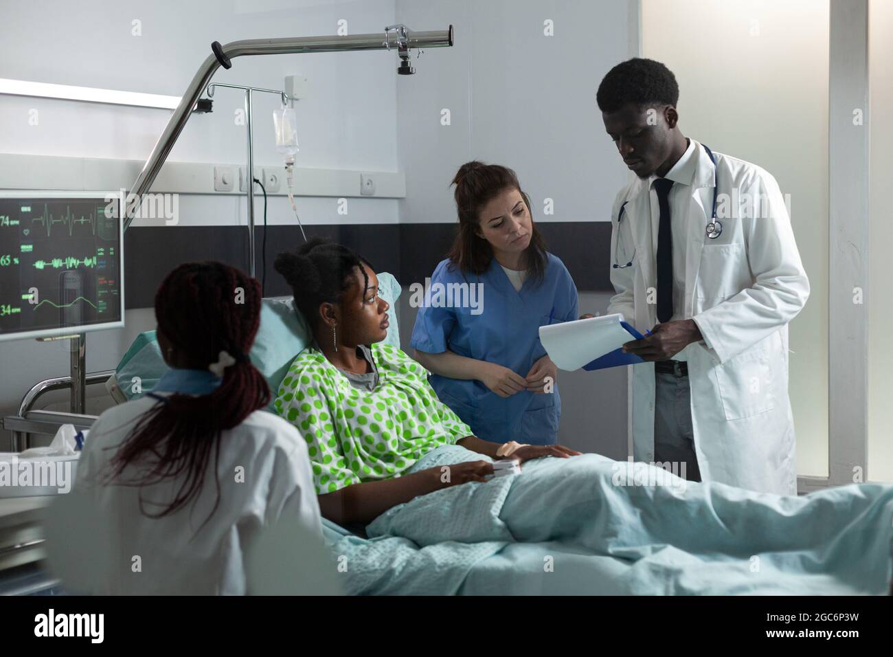 Diverse medical team consulting african american patient about disease ...
