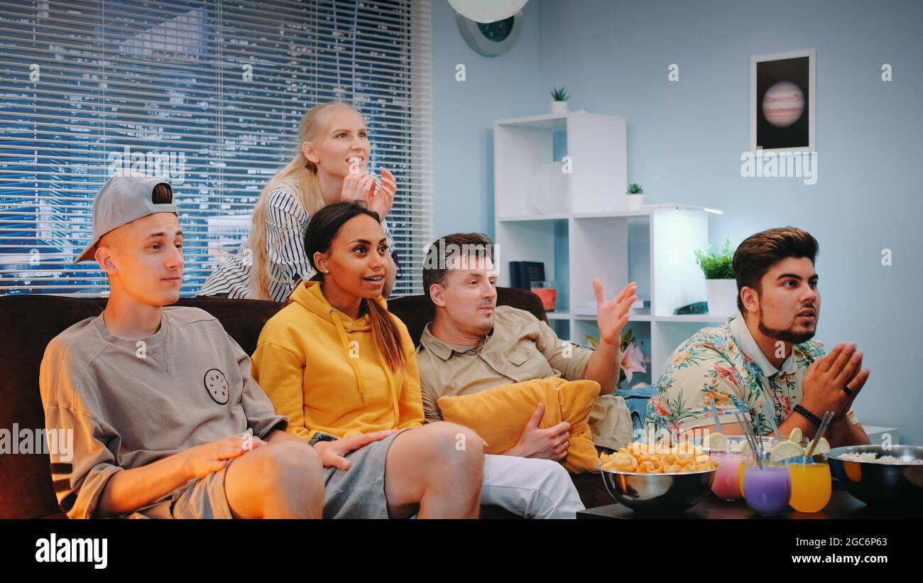 Happy viewers watching sports on TV and spilling popcorn when team ...
