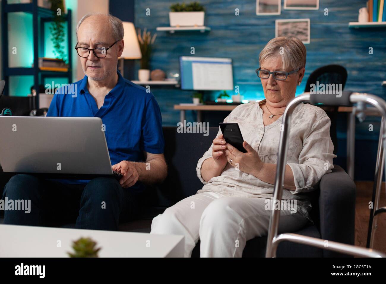 Retired elderly couple with smartphone and laptop computer using online ...