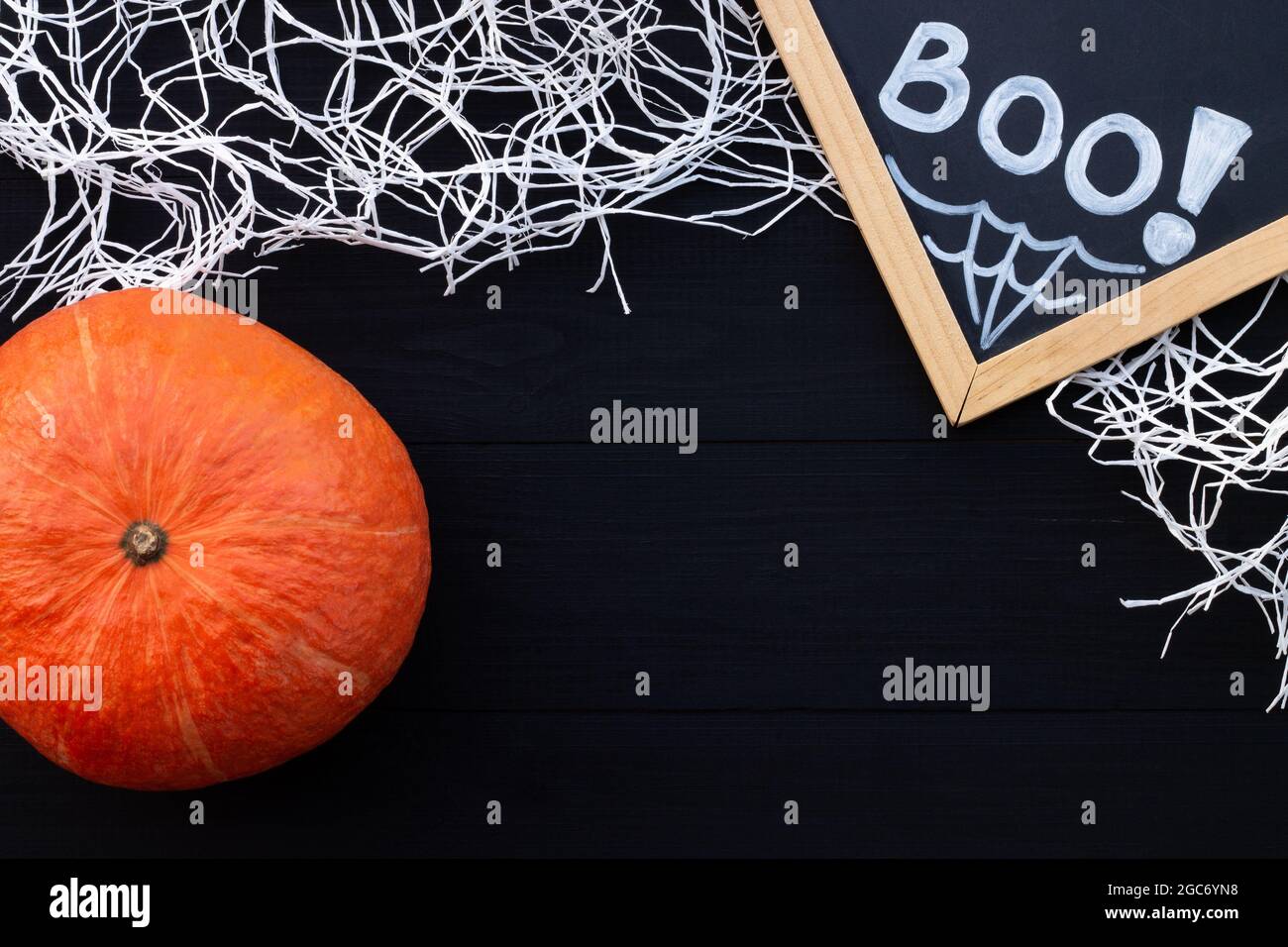 Orange and black Halloween flatlay. Chalk inscription BOO, pumpkin and ...