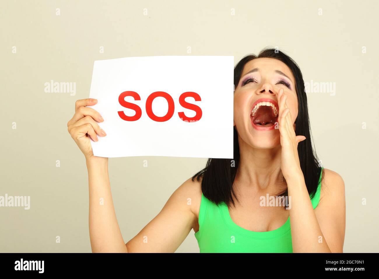Girl showing stop sign on grey background Stock Photo - Alamy