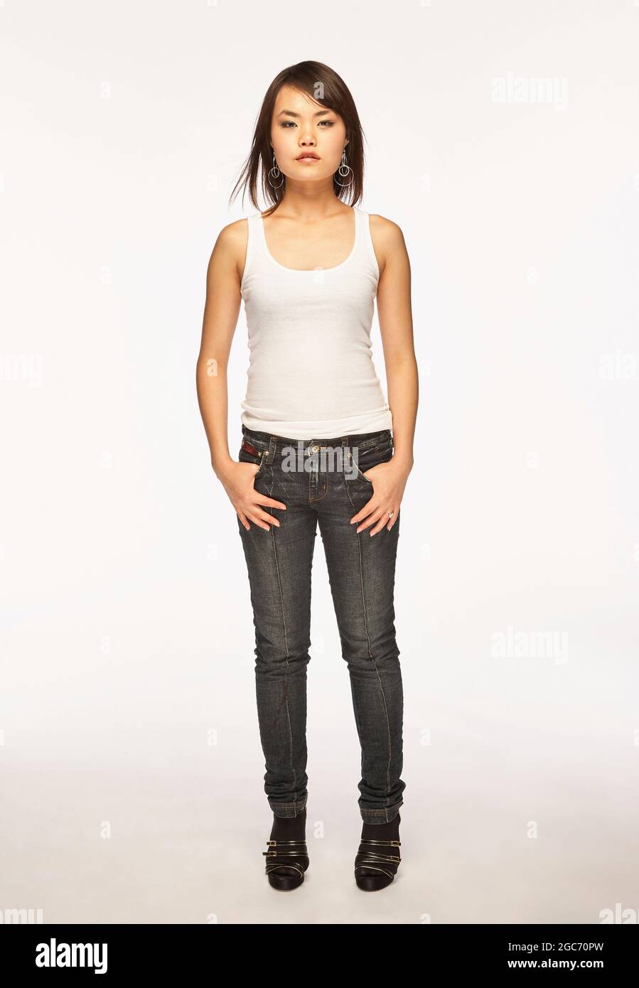 Studio portrait of woman in white tank top Stock Photo - Alamy