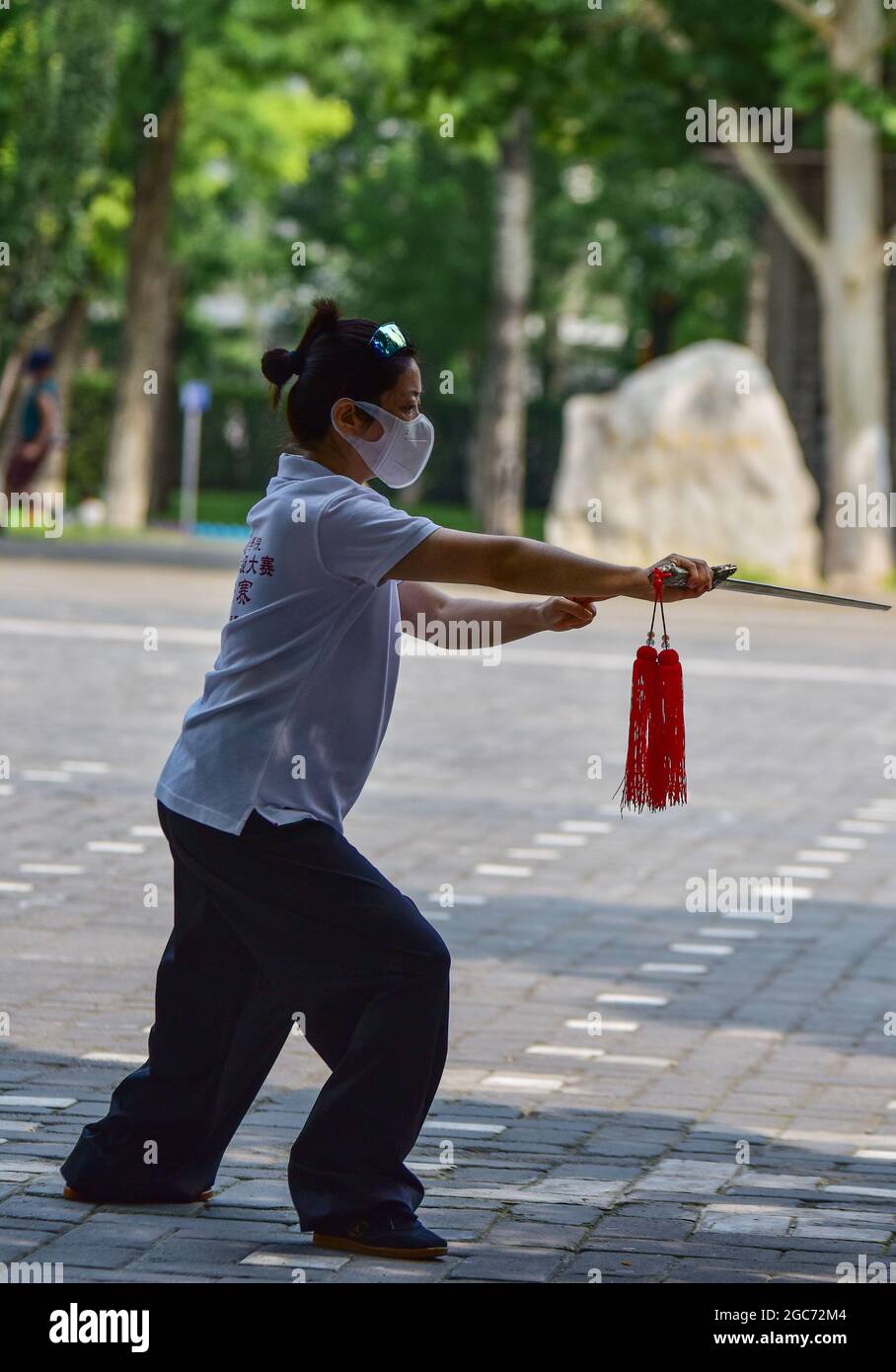 BEIJING, CHINA - AUGUST 7, 2021 - People wearing masks dance with ...
