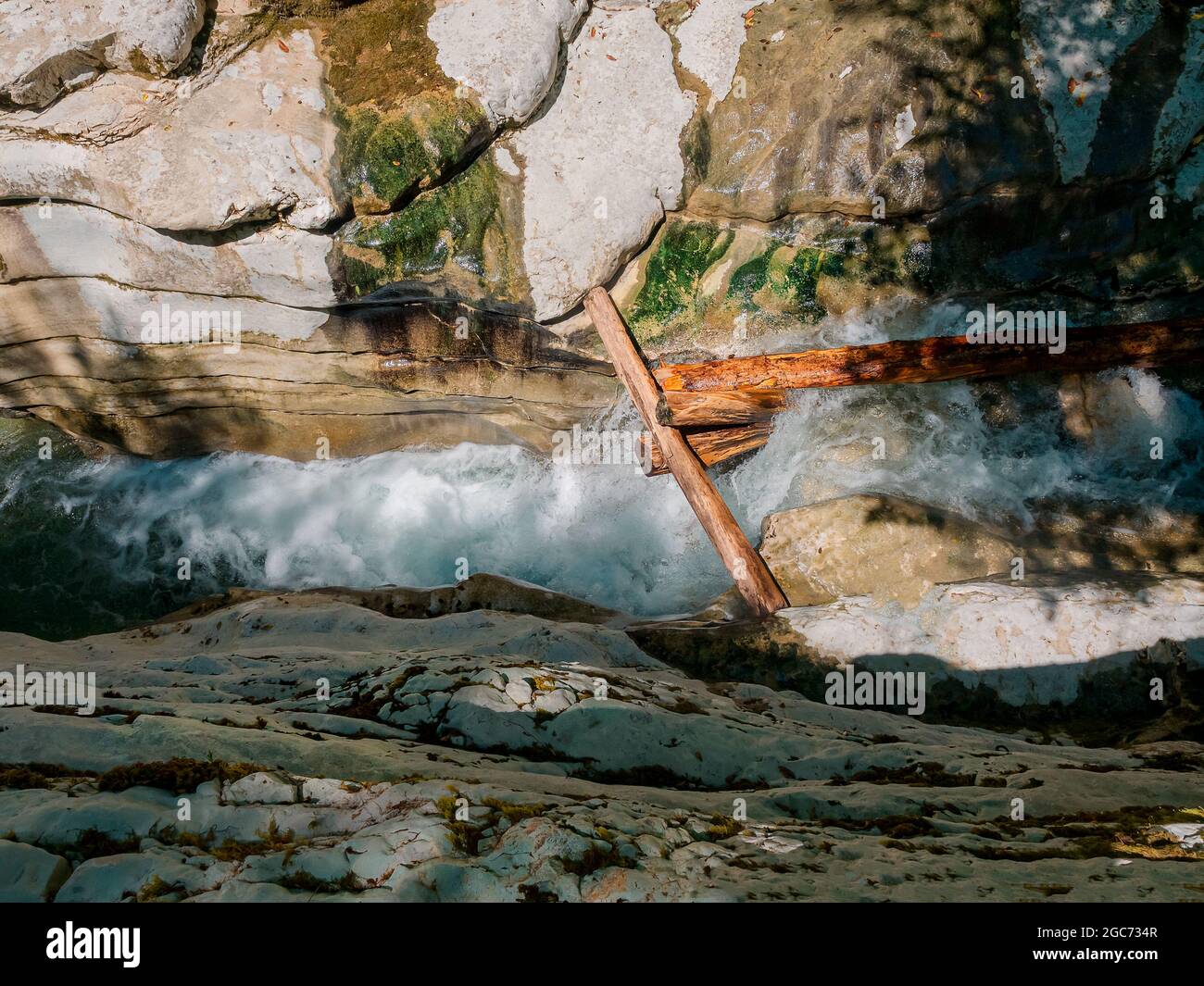 A foamy, turbulent river flows in narrow gorge between the canyons ...