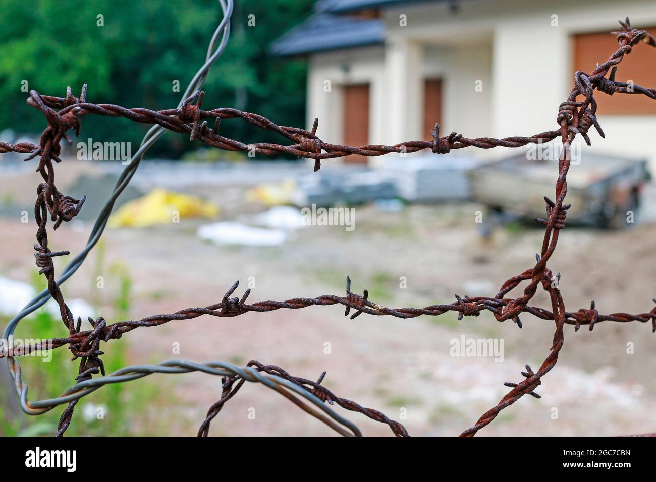 Barbed wire in front of the building. Security tools Stock Photo - Alamy