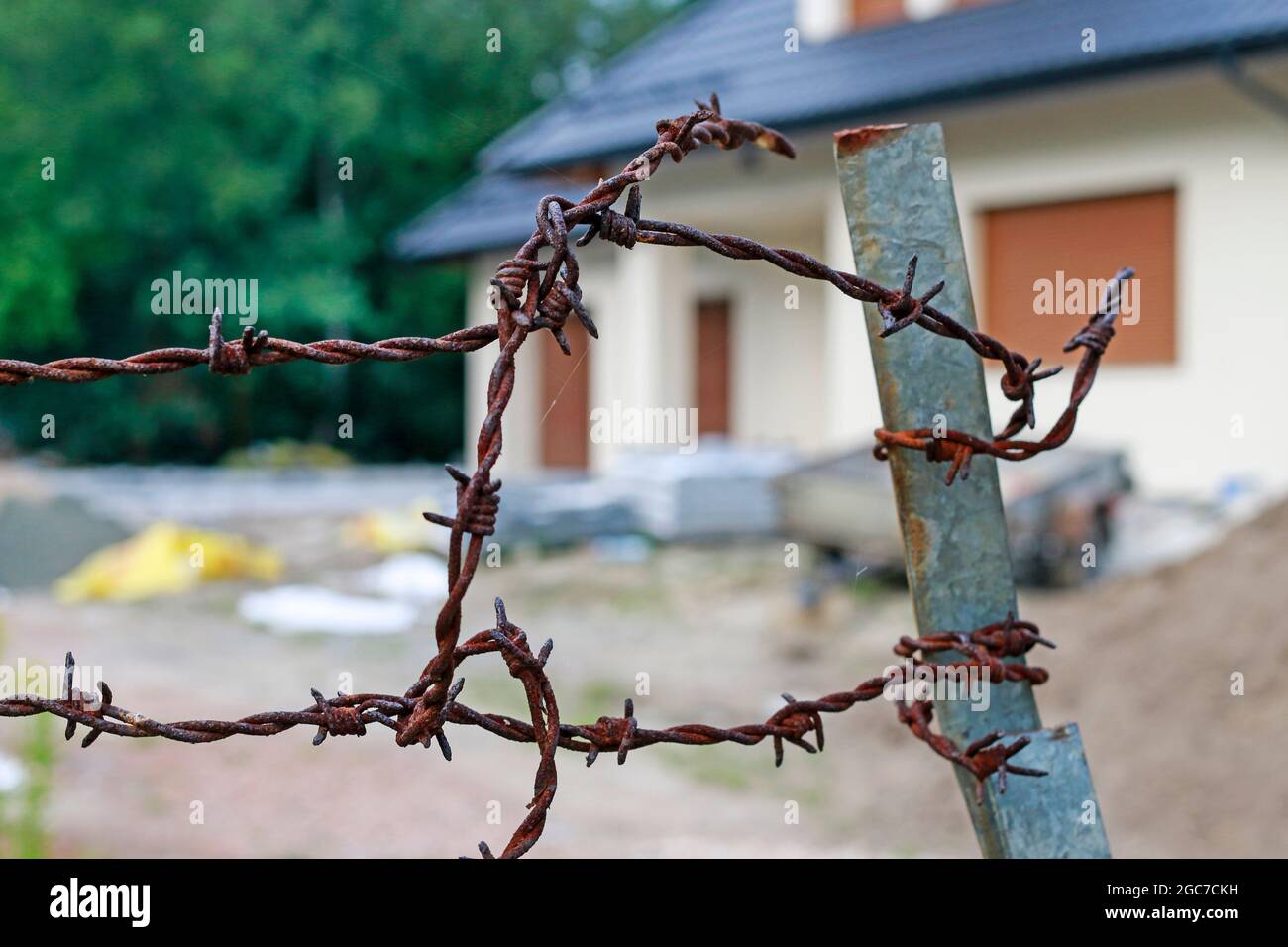 Barbed wire in front of the building. Security tools Stock Photo - Alamy
