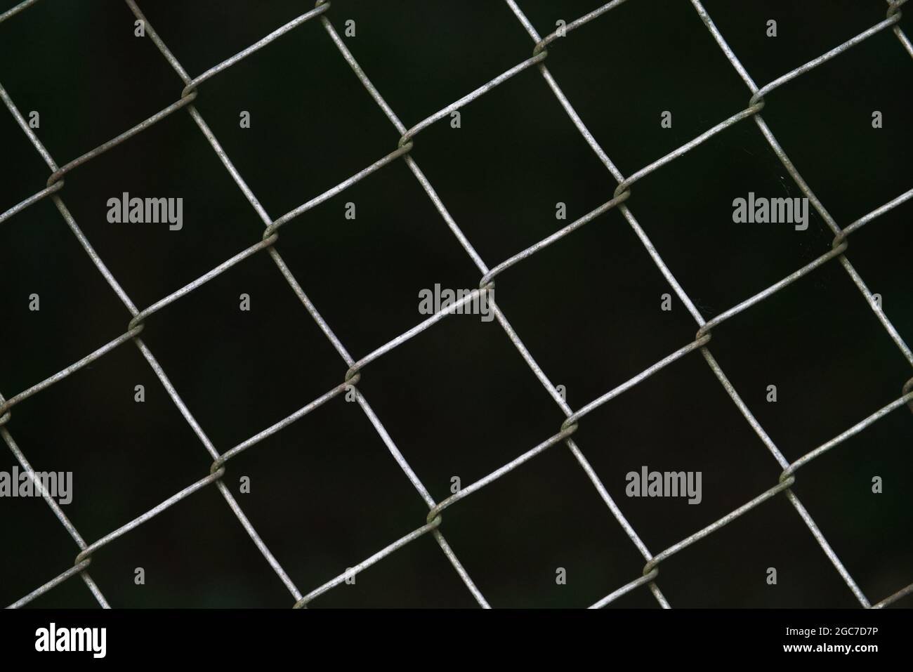 wire mesh fence with dark background Stock Photo - Alamy