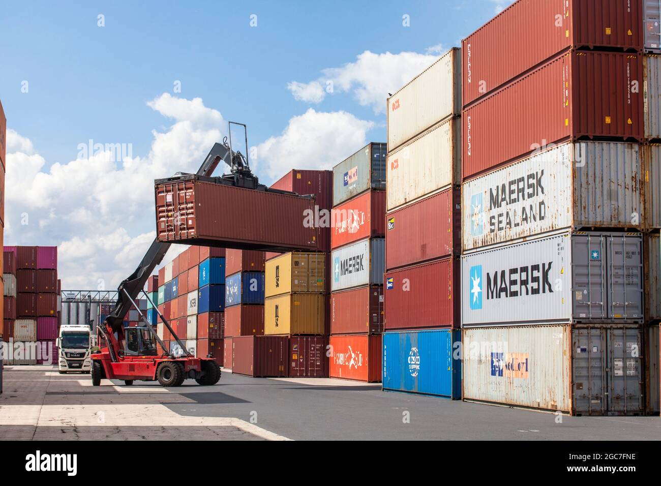 a reach stacker loads containers at the container terminal of the Rhine ...