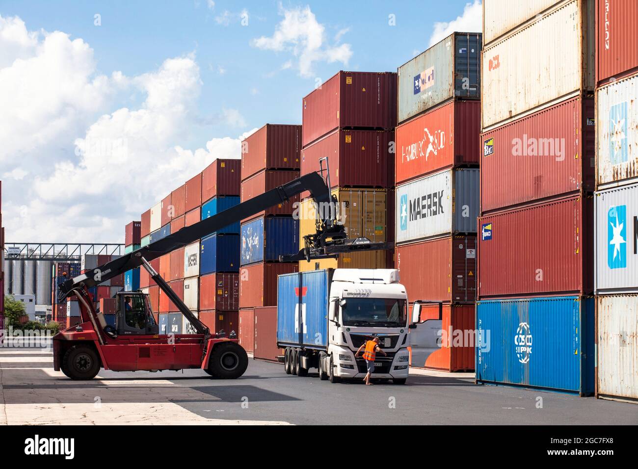 a reach stacker loads containers at the container terminal of the Rhine ...