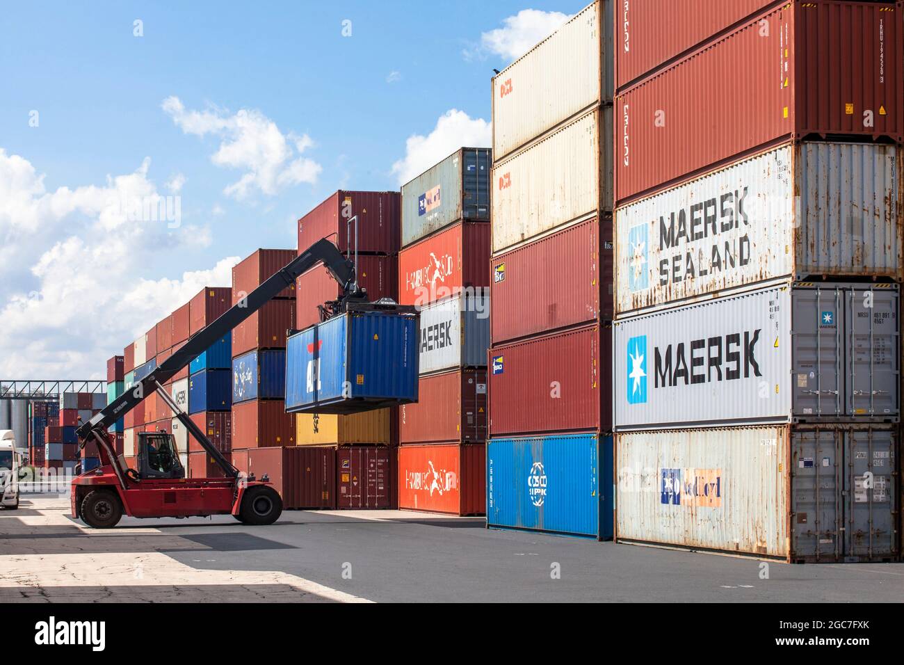 a reach stacker loads containers at the container terminal of the Rhine ...