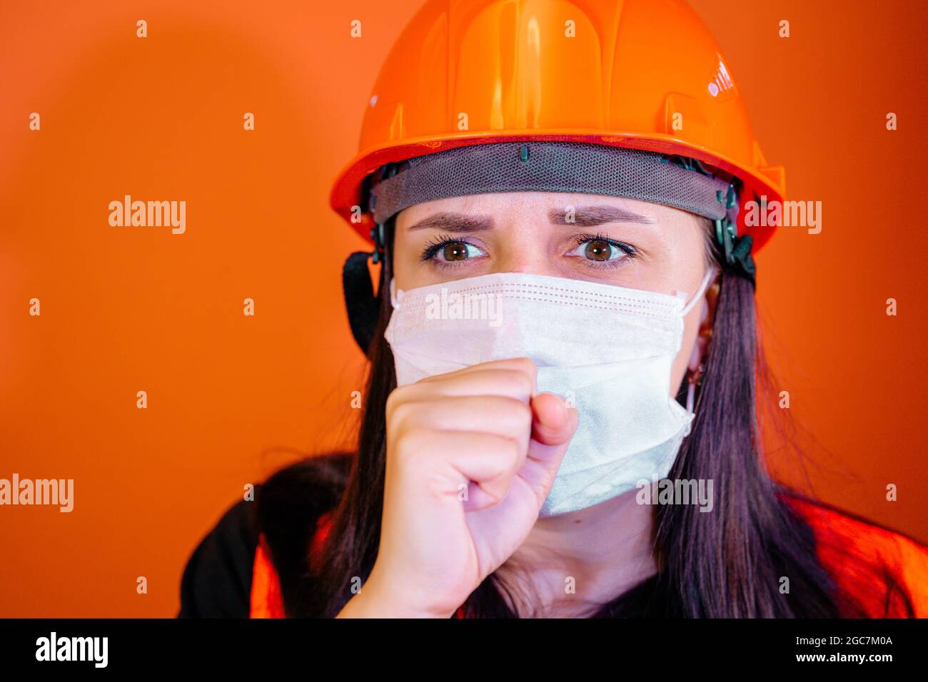 Female construction worker in overalls and medical mask coughing Stock ...