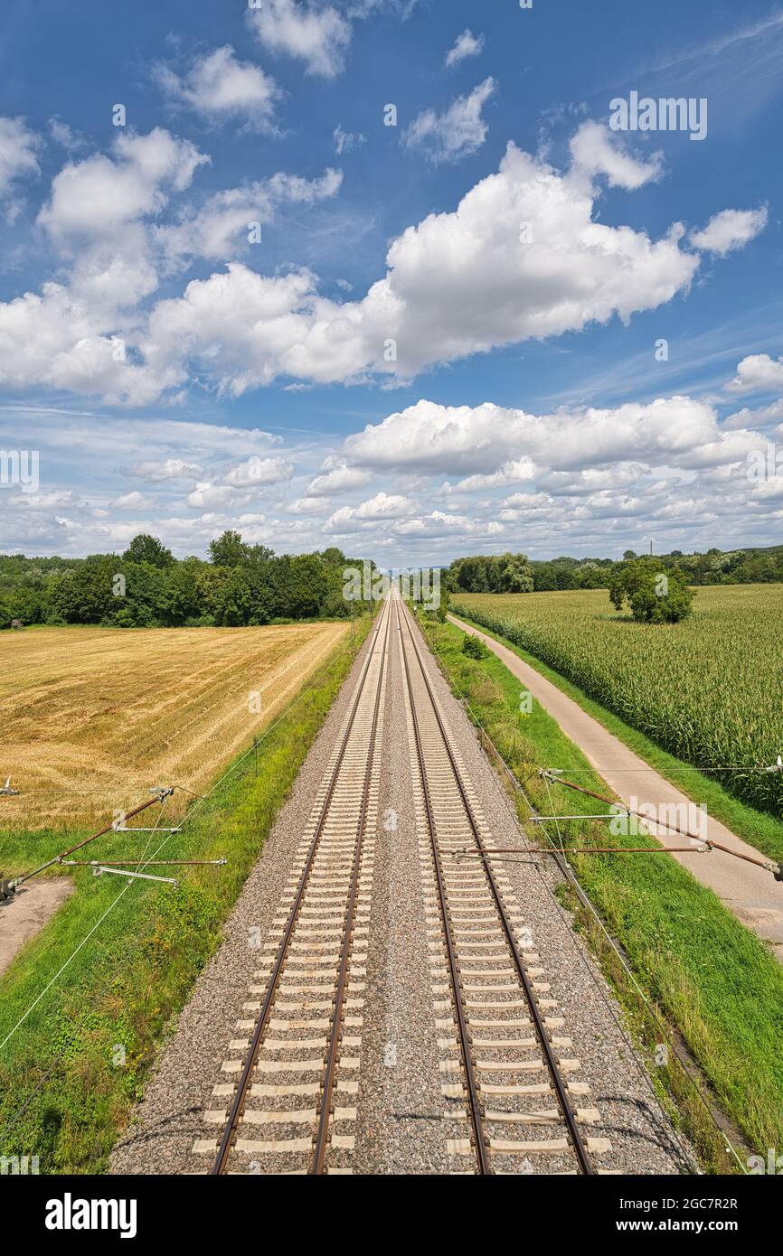 railroad tracks lie parallel in the track bed, in the background a ...