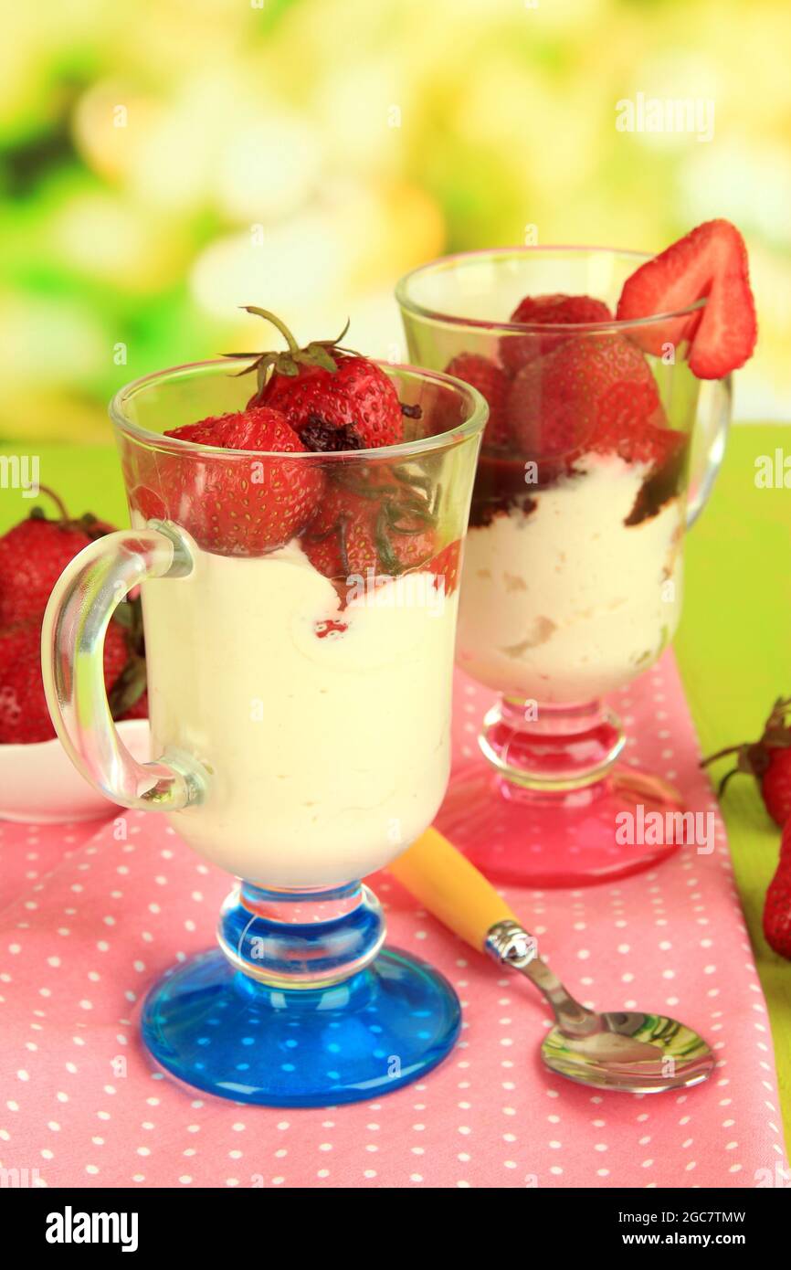 Delicious strawberry desserts in glass vase on wooden table on natural ...