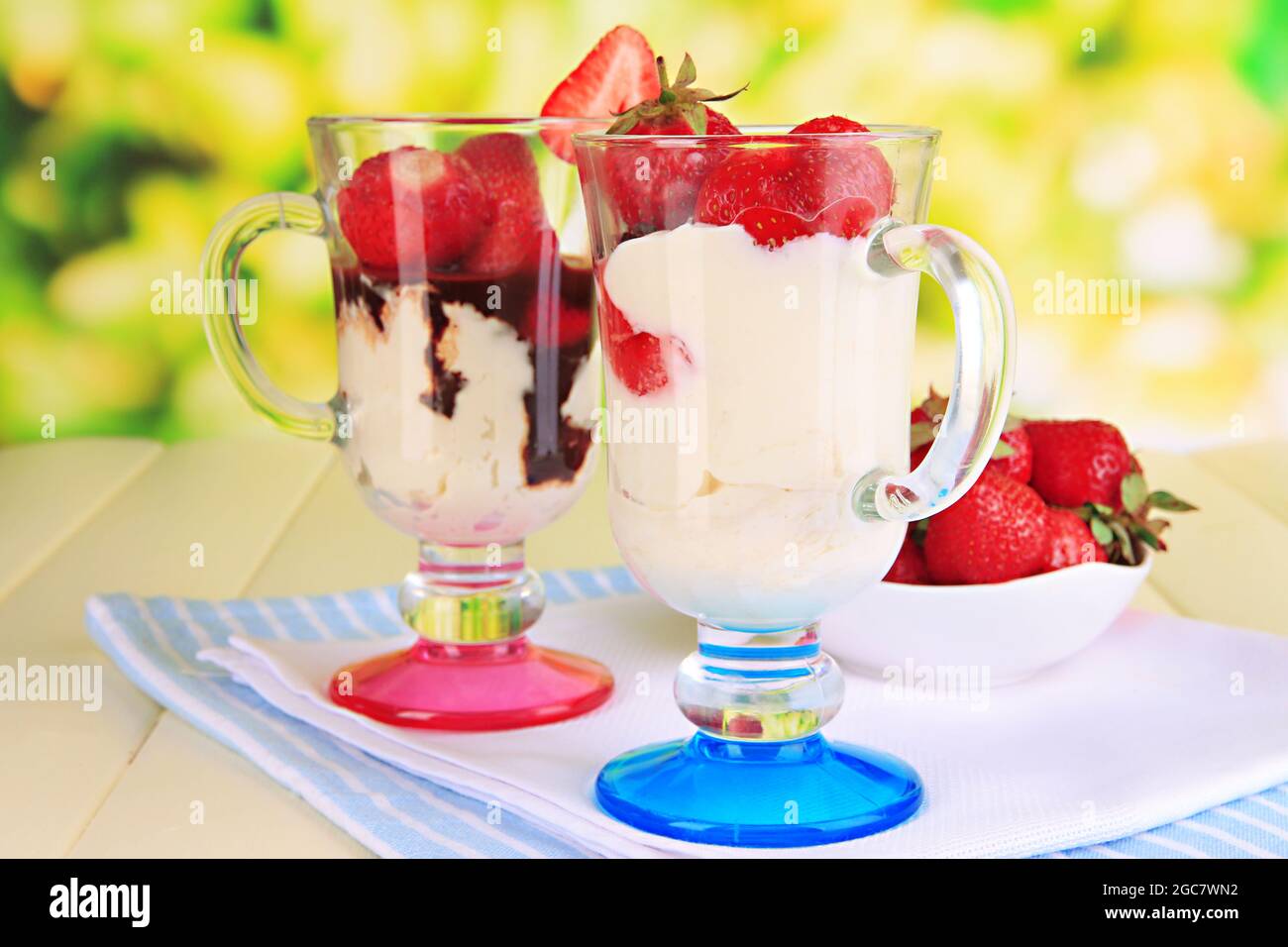 Delicious strawberry desserts in glass vase on wooden table on natural ...