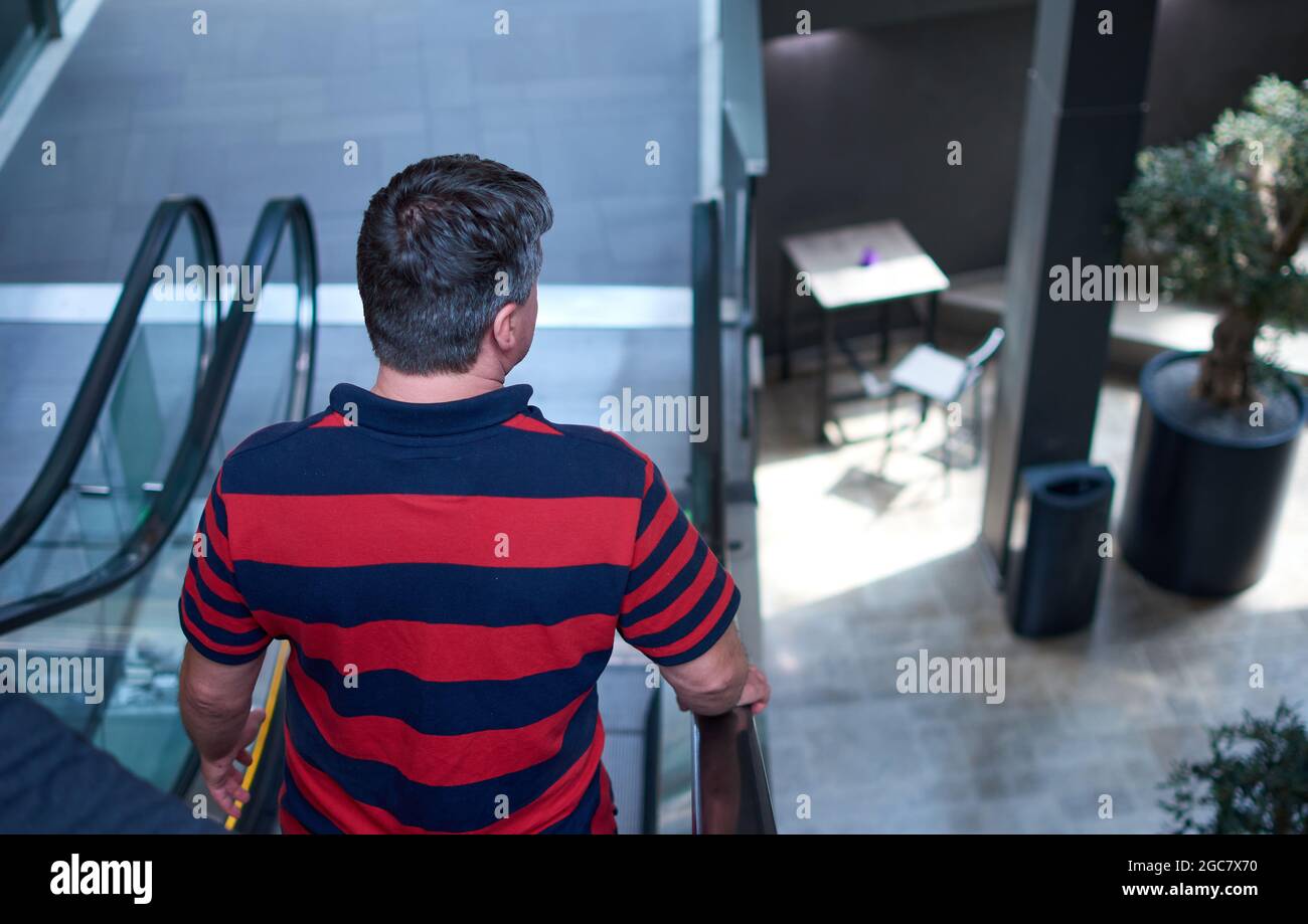 Back view of a caucasian man going down by the escalator Stock Photo ...