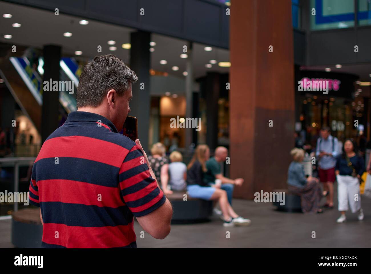 Back view of a caucasian man walking on the street and talking on his ...