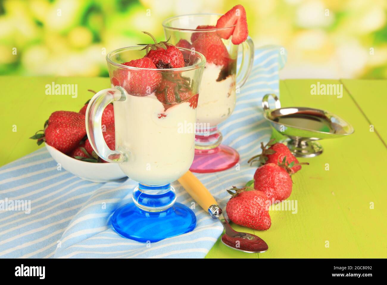 Delicious strawberry desserts in glass vase on wooden table on natural ...
