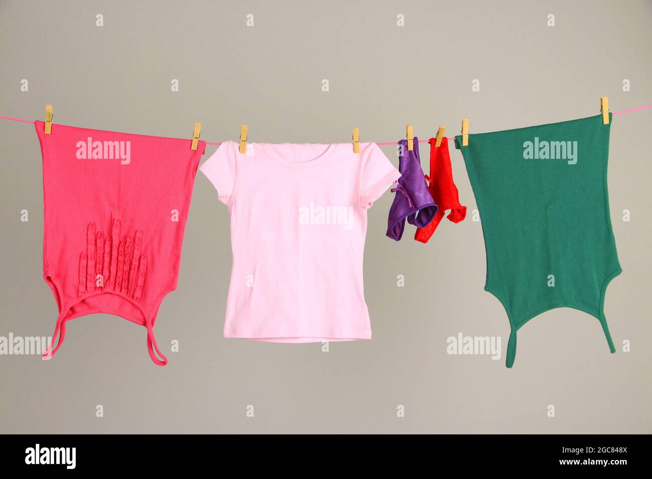 Laundry line with clothes on wall background Stock Photo - Alamy