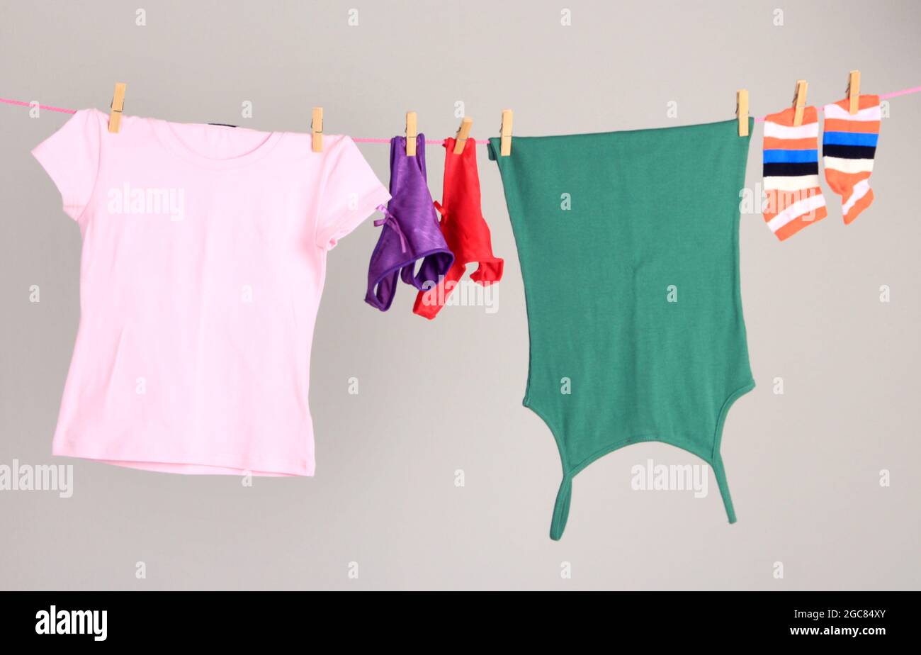 Laundry line with clothes on wall background Stock Photo - Alamy