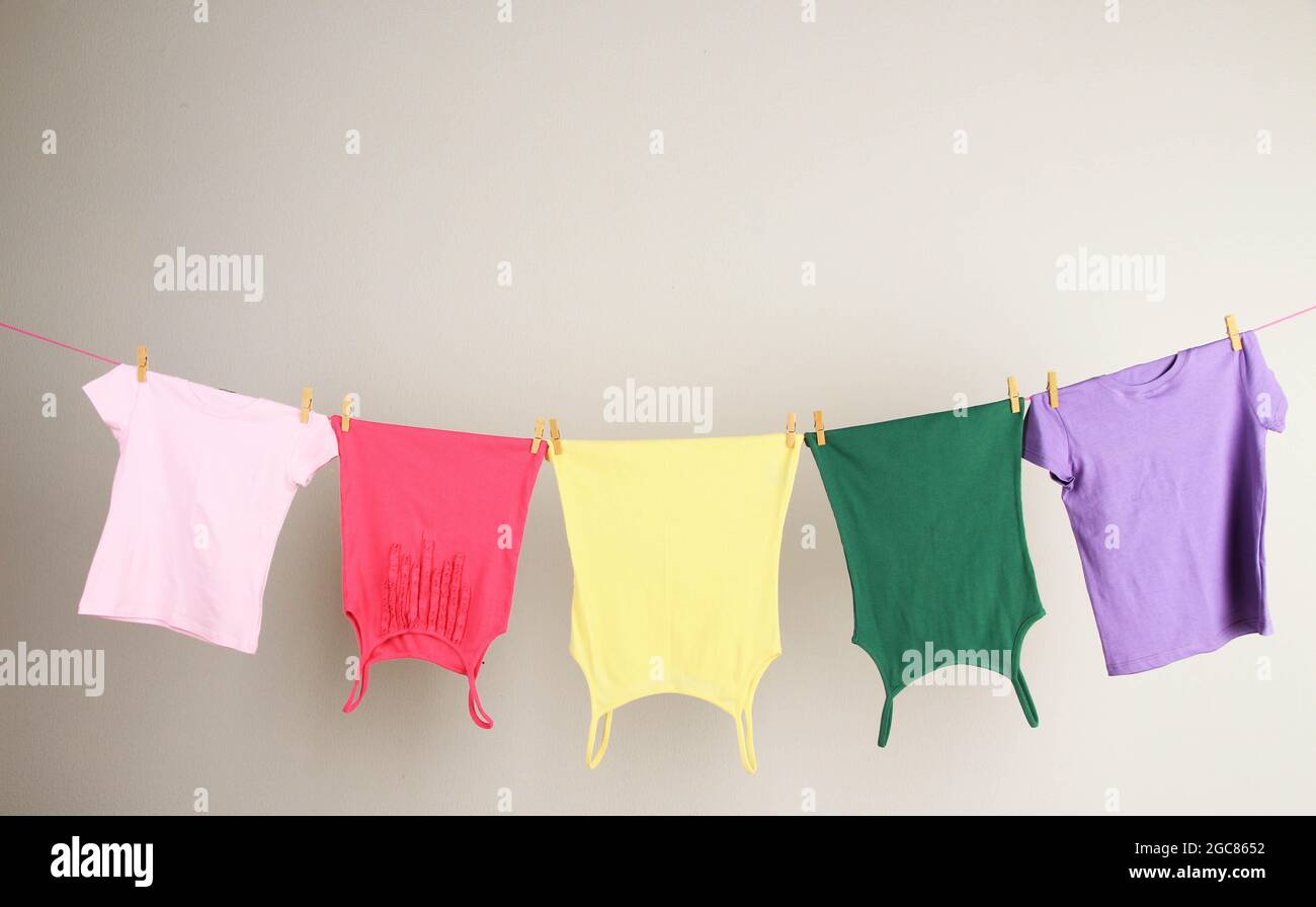 Laundry line with clothes on wall background Stock Photo - Alamy