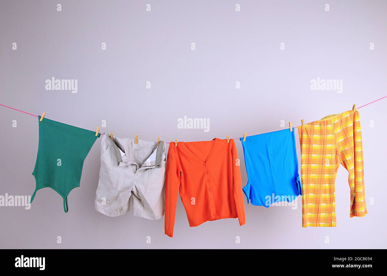 Laundry line with clothes on wall background Stock Photo - Alamy