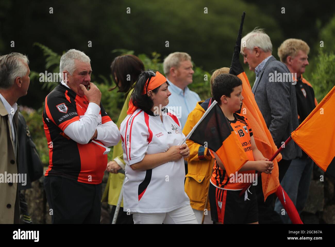 Members of St Colum's GAA club line up as the coffin of Father Con ...