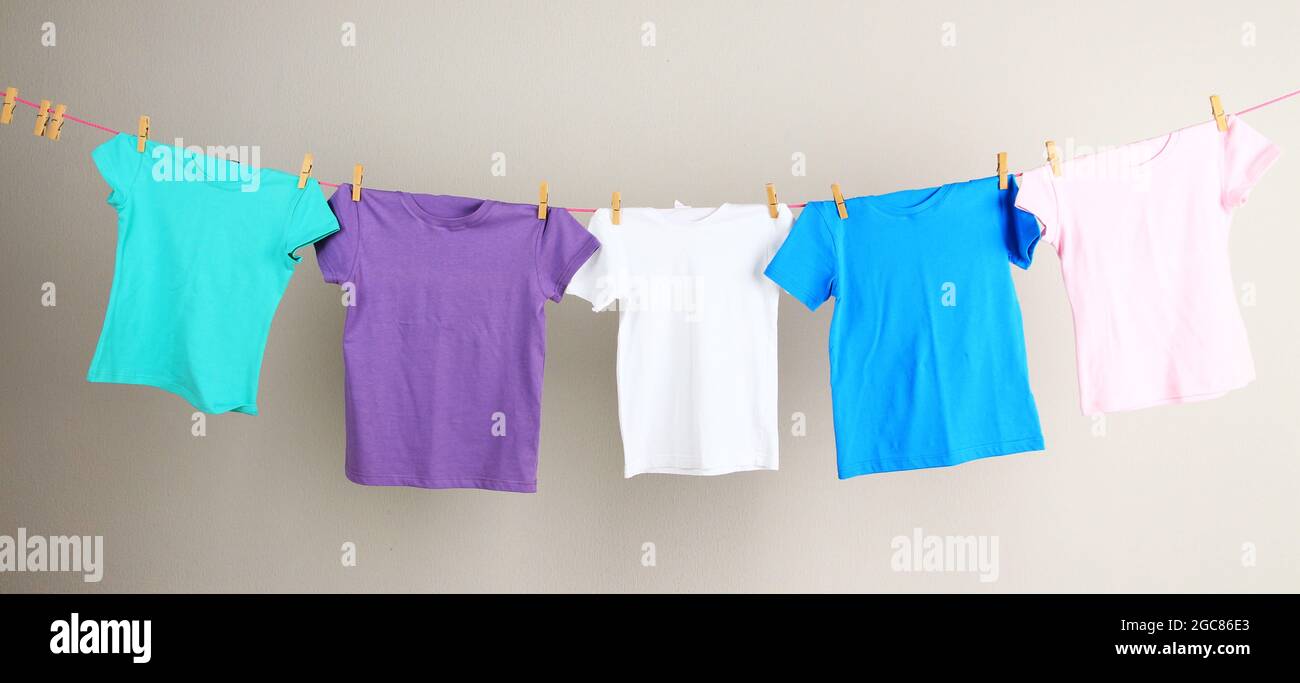 Laundry line with clothes on wall background Stock Photo - Alamy